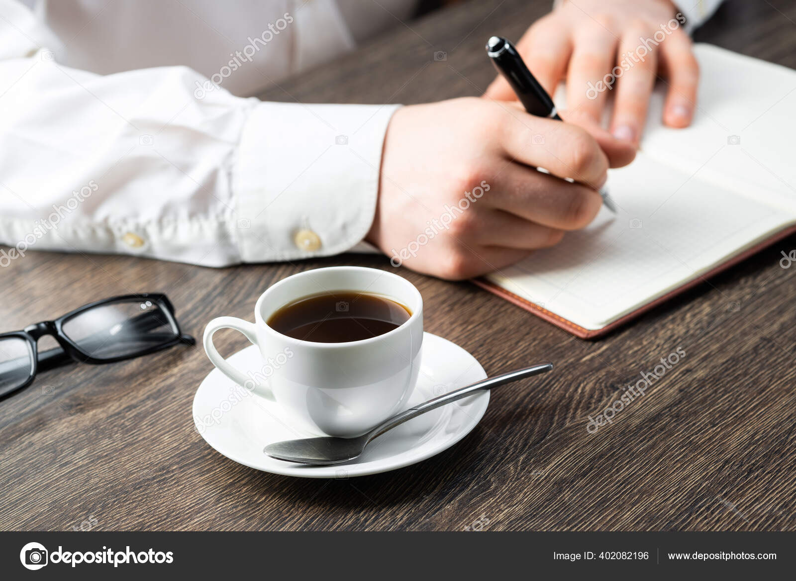 Man making notes with pen in notebook Stock Photo by ©Khakimullin 402082196