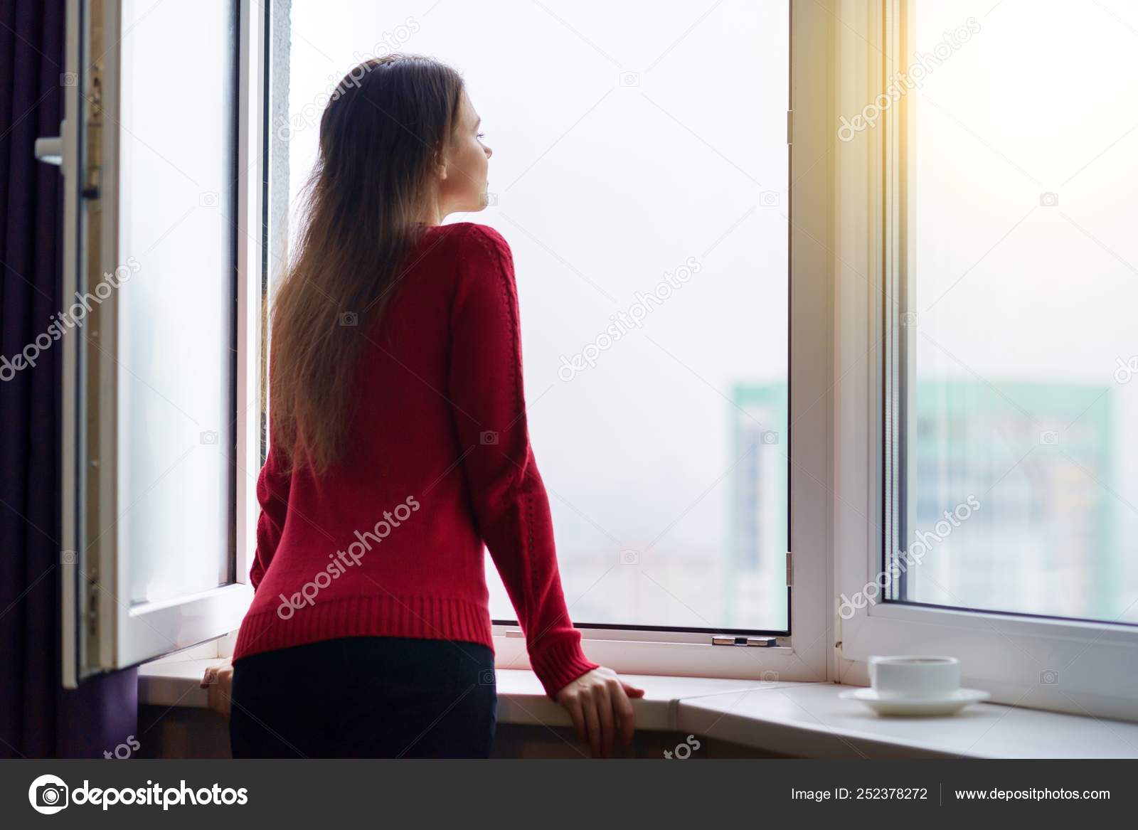 Young woman opened a window enjoying the fresh air, side view Stock ...
