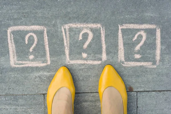 Woman feet with 3 question marks in front of her legs painted on the ...