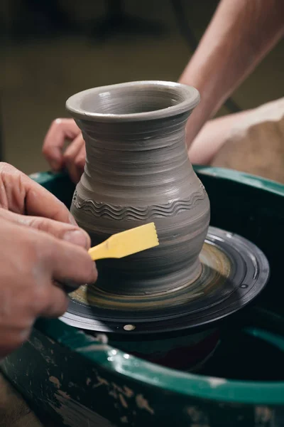 Close up on hands , potter working on the wheel shaping clay mak ...