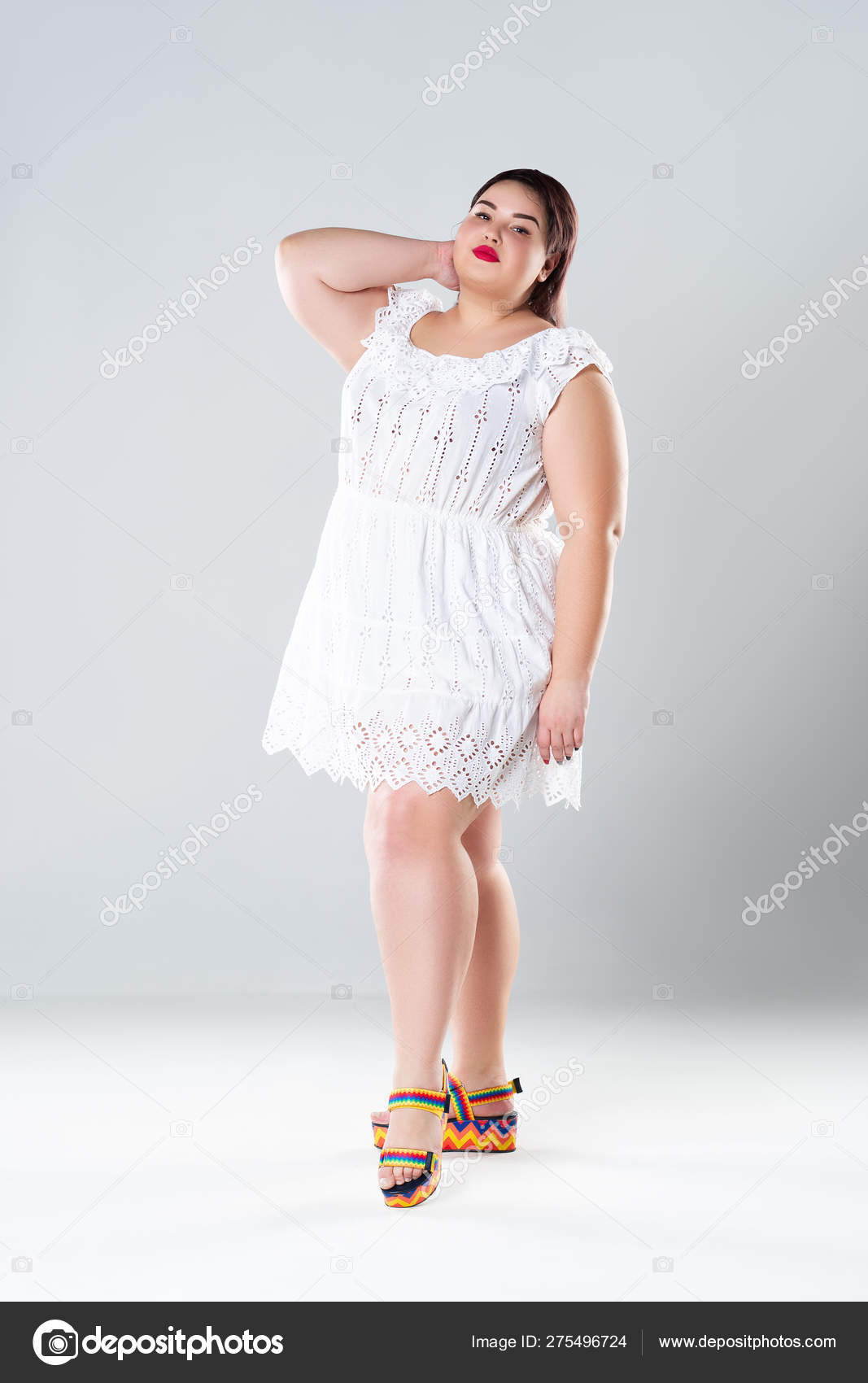 Plus size fashion model in white dress, fat woman on gray background ...