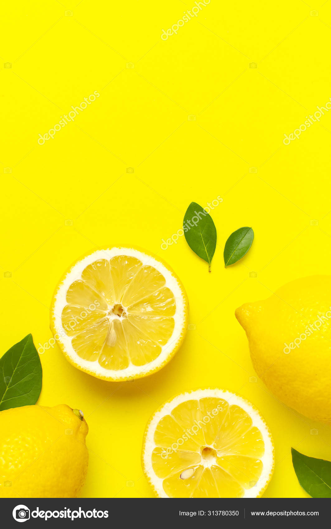 Creative background with fresh lemons and green leaves on bright yellow ...