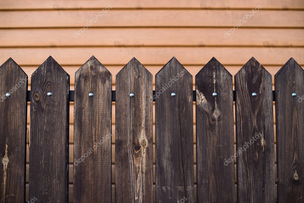 Cerca de madera apuntada en el telón de fondo de la casa con la ...
