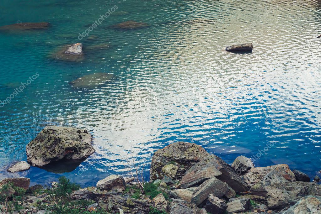 Piedras musgosas en el lago de montaña brillante. Fondo texturizado de ...