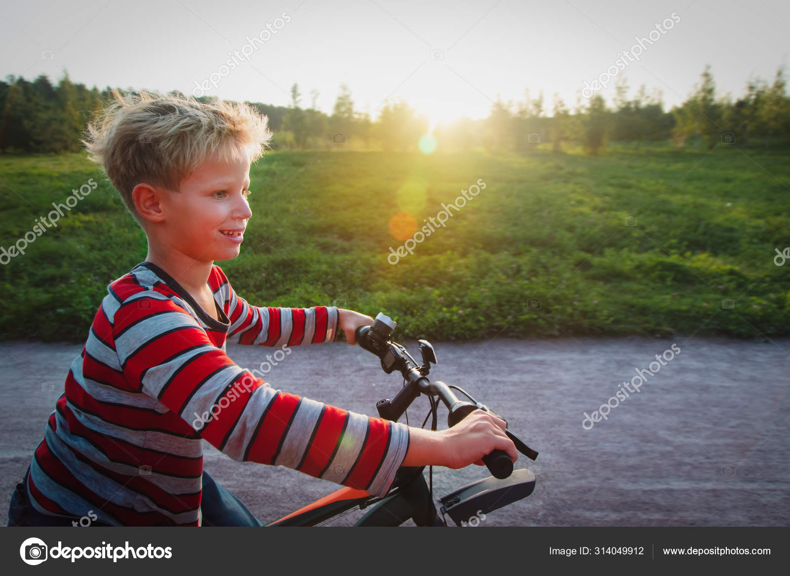 Happy cute boy enjoy riding bike in sunset nature Stock Photo by ...