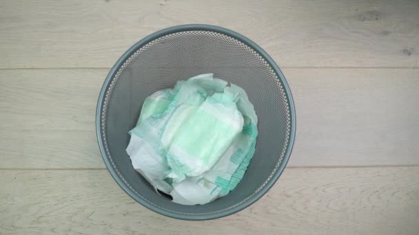 Woman throws dirty diapers into the trash. Disposing of used nappies ...