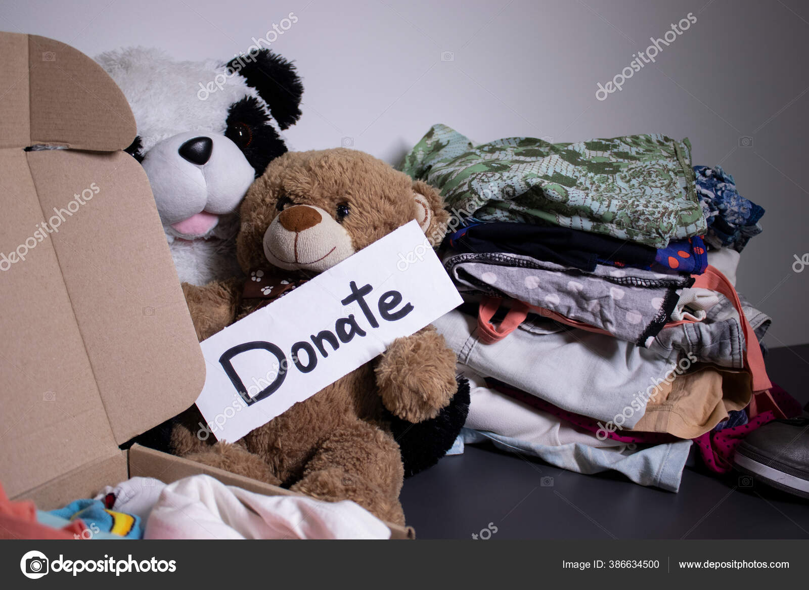 Donar signo escrito a mano con letras negras. Una caja con ropa y una ...