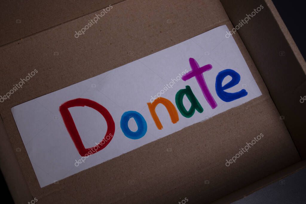 Donar signo escrito a mano con letras multicolores en una caja ...