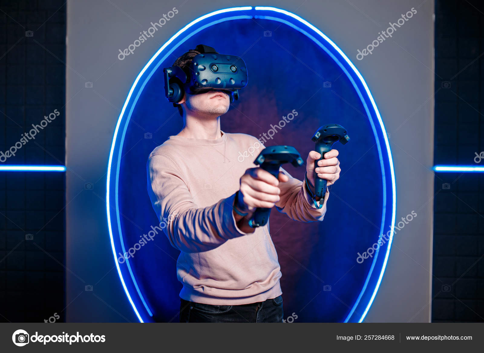 A young guy plays video games in a game room in a virtual reality ...