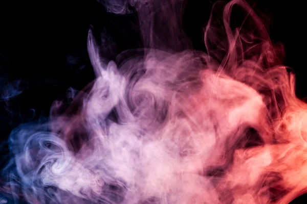Dense red,blue and white smoke on a black isolated background ...