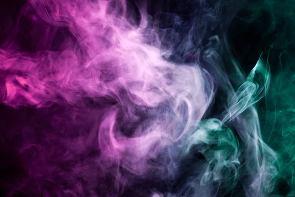 Dense pink, green and white smoke on a black isolated background ...