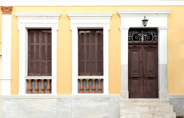 Wooden retro style door and two windows with brown shutters, on clean ...