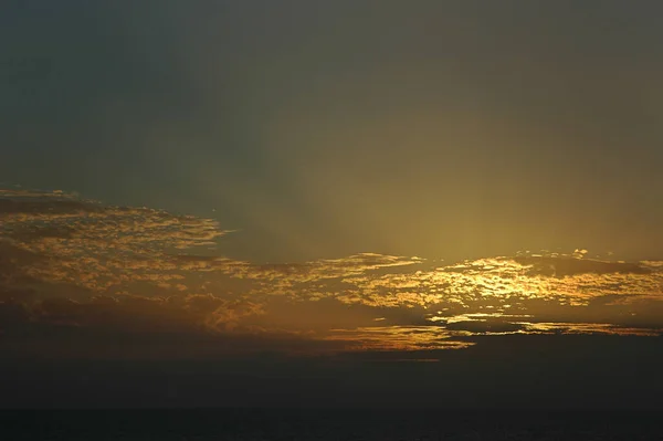 Dramatic sunset with beautiful and faint rays of light through the ...