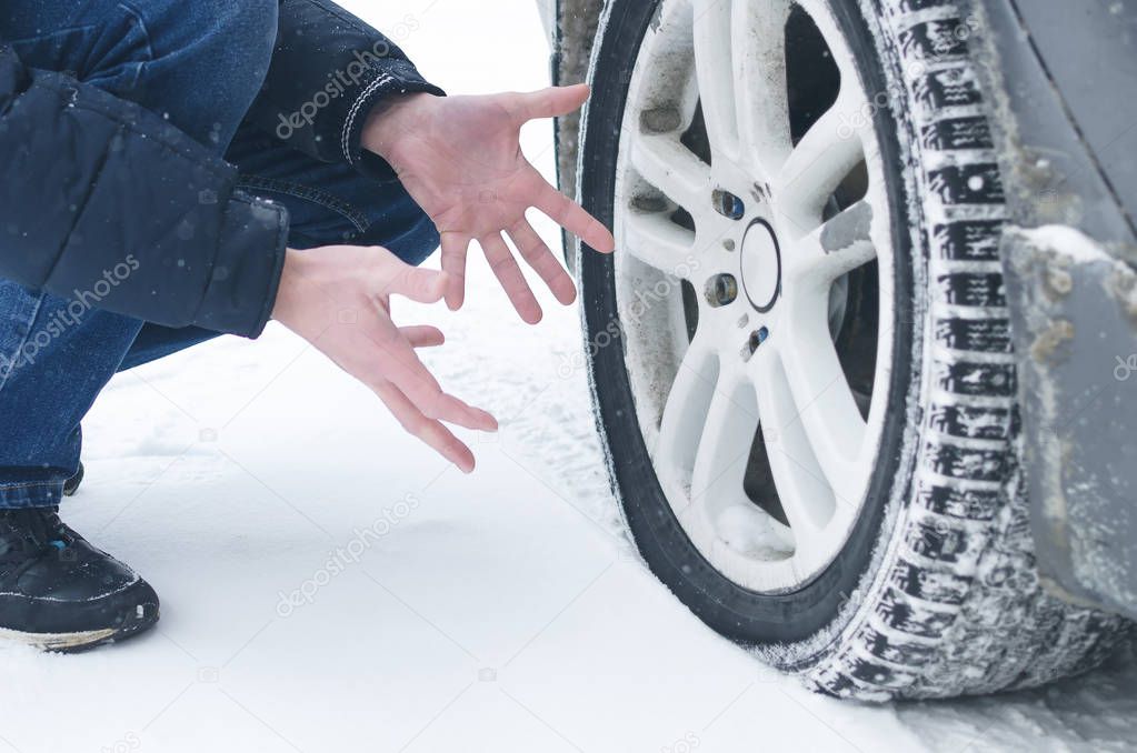 El conductor est extendiendo su mano y confundido por el neum tico pinchado de su coche ...