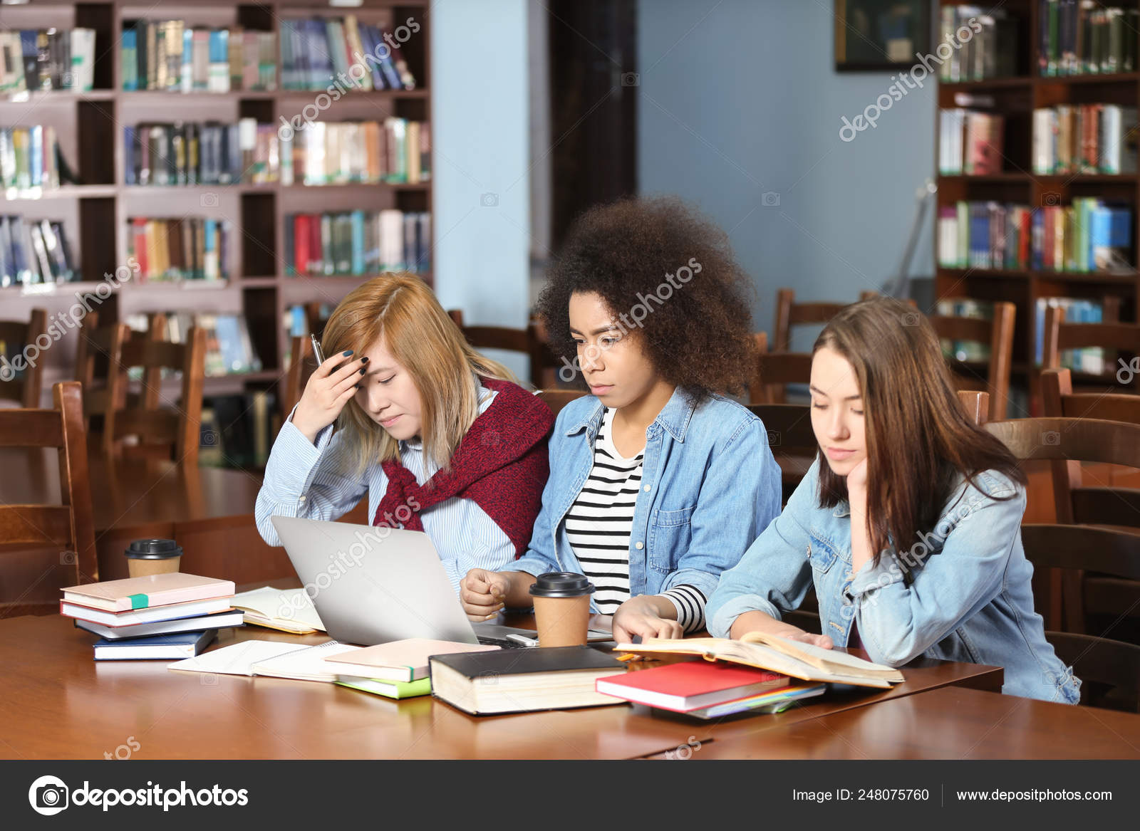 Group of students studying at table in library Stock Photo by ...