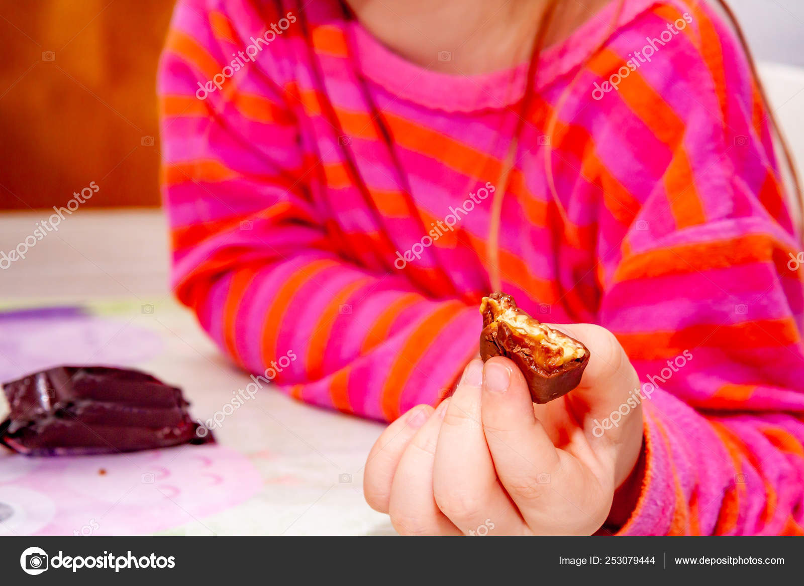 Little girl eating Snickers chocolate bar for breakfast Stock Photo by ...
