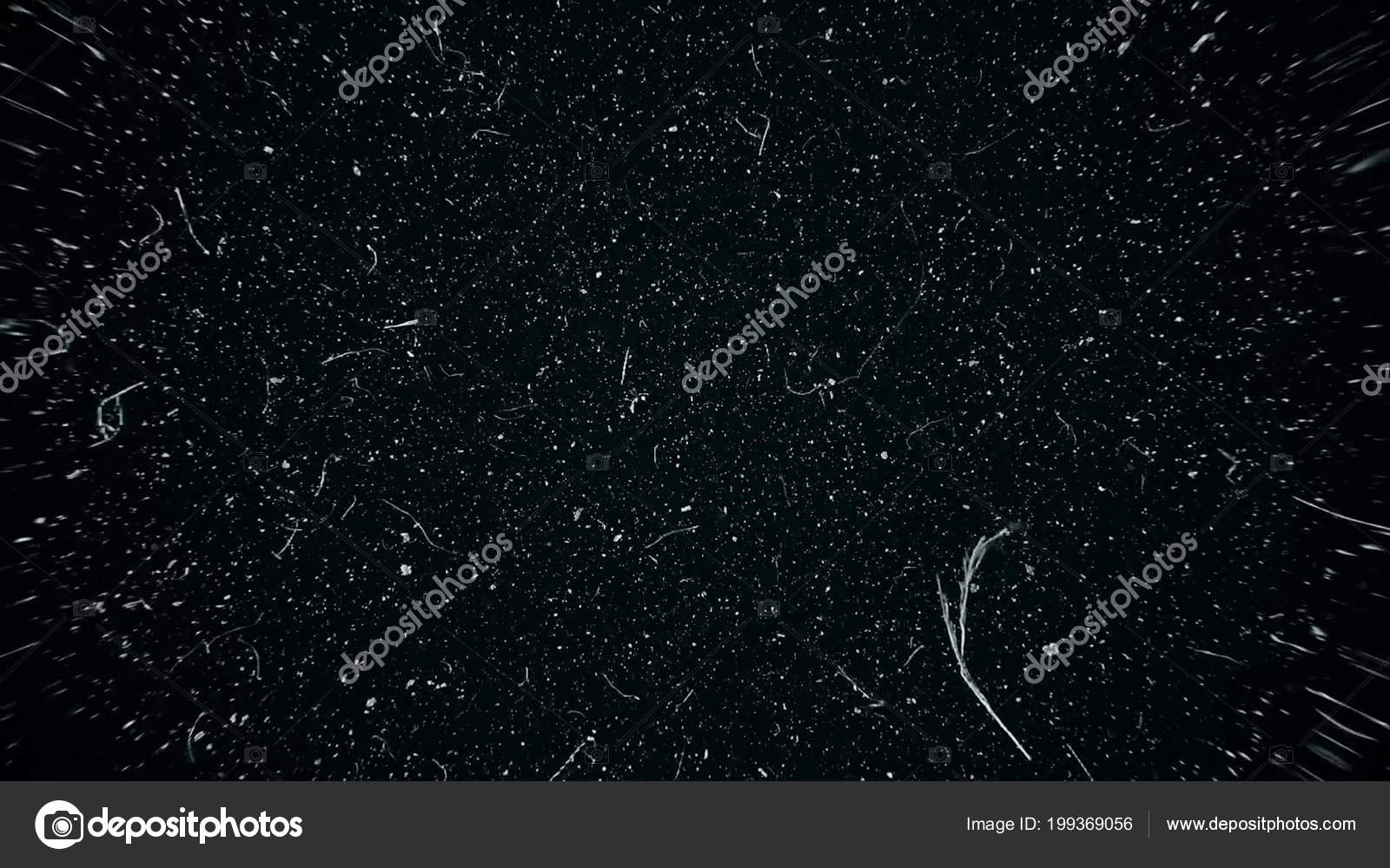White dust particles moving slowly in space on black background ...