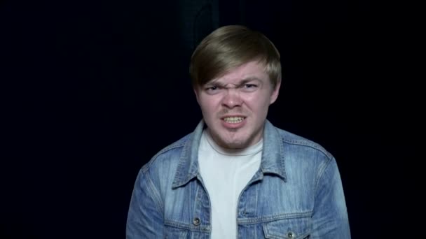 Man showing his tongue. Young man angrily grimaces and out tongue ...