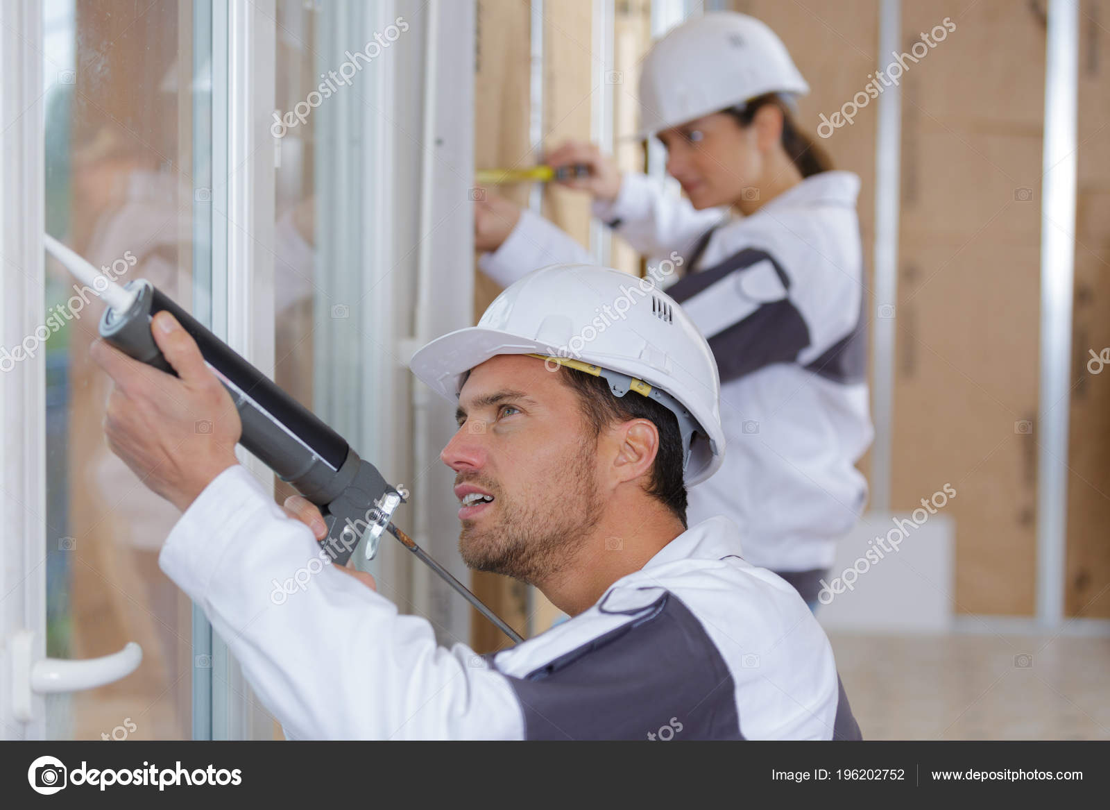 Team of construction workers installing window in house Stock Photo by ...