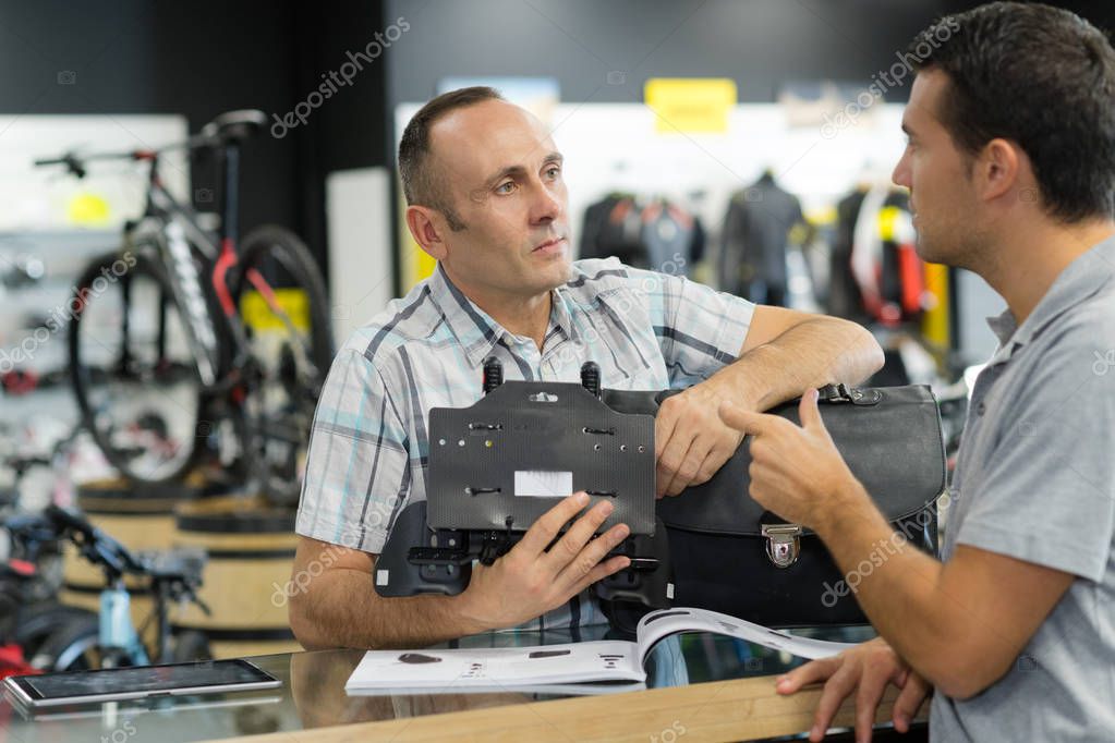 hombre pidiendo ayuda al vendedor en la tienda de bicicletas deportivas ...