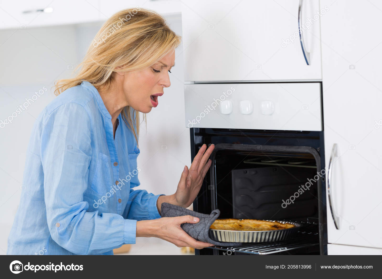 Woman burn hand while getting a tart off the oven — Stock Photo ...