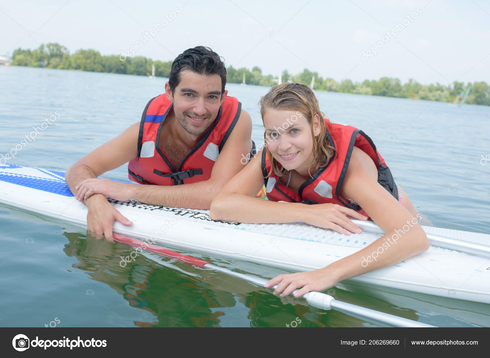 Young couple swiming with paddle board in a lake Stock Photo by ...