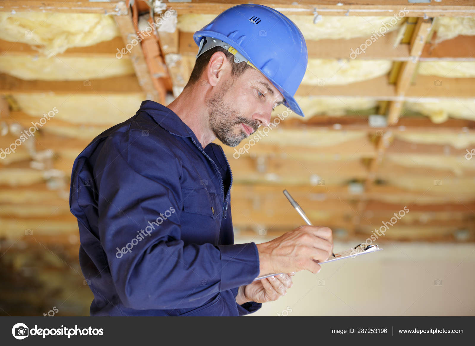Male engineer writing on clipboard at construction site Stock Photo by ...