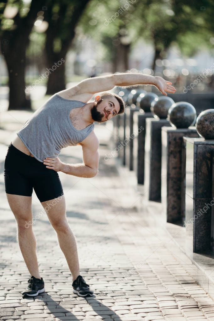 Hombre calentándose al aire libre, estirando los brazos y los costados 2022