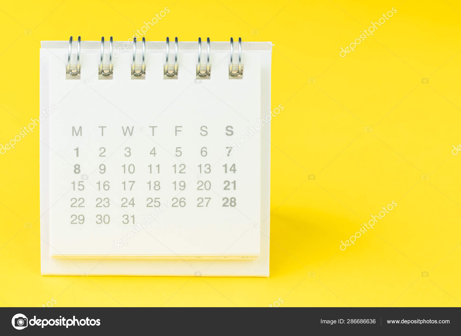 White clean desktop calendar on solid yellow background with cop ...