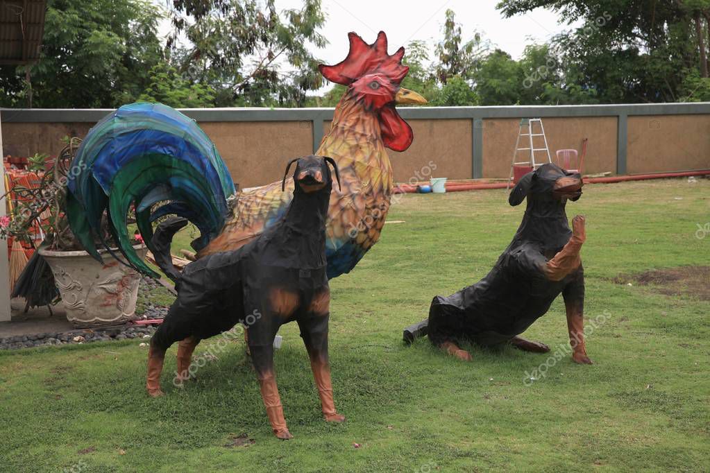 Estatuas de dos perros y un enorme gallo en un brillante colorido en el ...