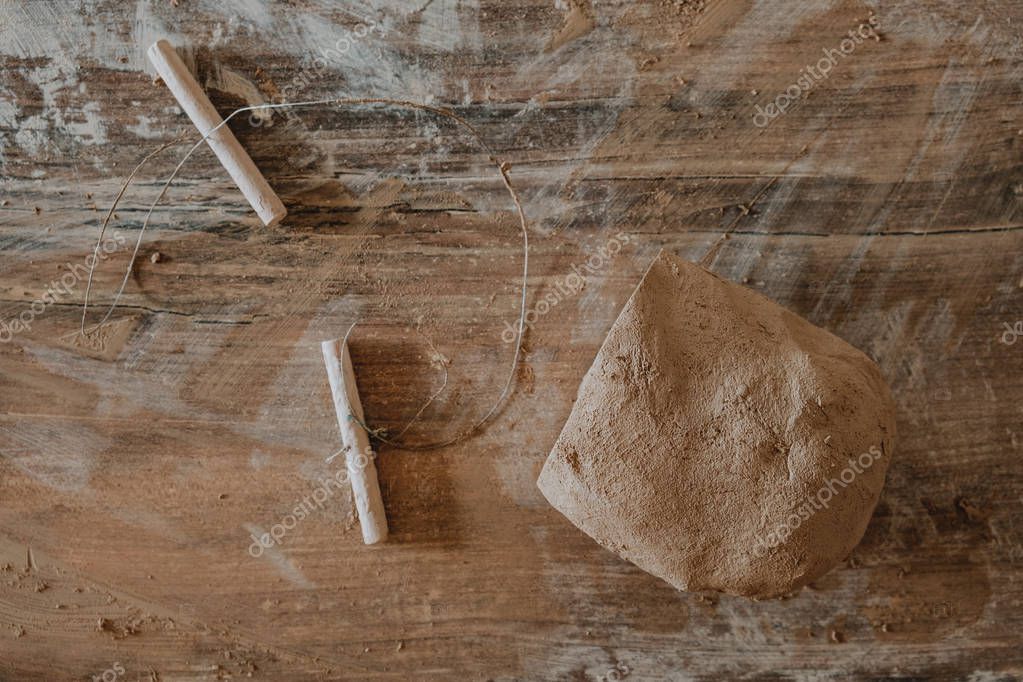 Pedazo de arcilla cortada con cuerda tendida sobre mesa de madera ...