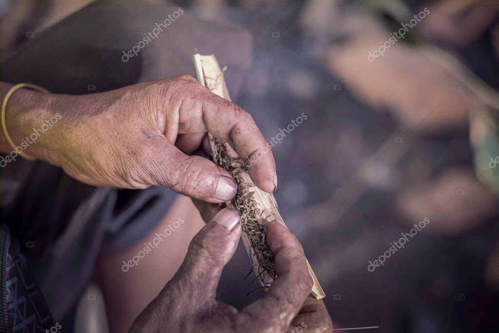 Indígenas aborígenes malasios fumando un cigarrillo mientras hacen un ...