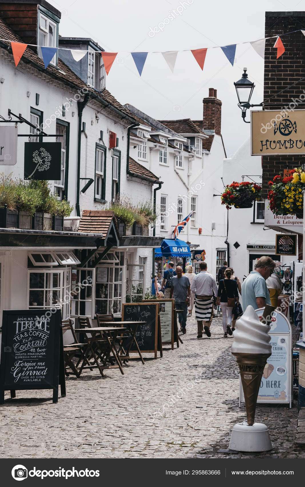 People walking under the colourful bunting on a street in Lyming ...