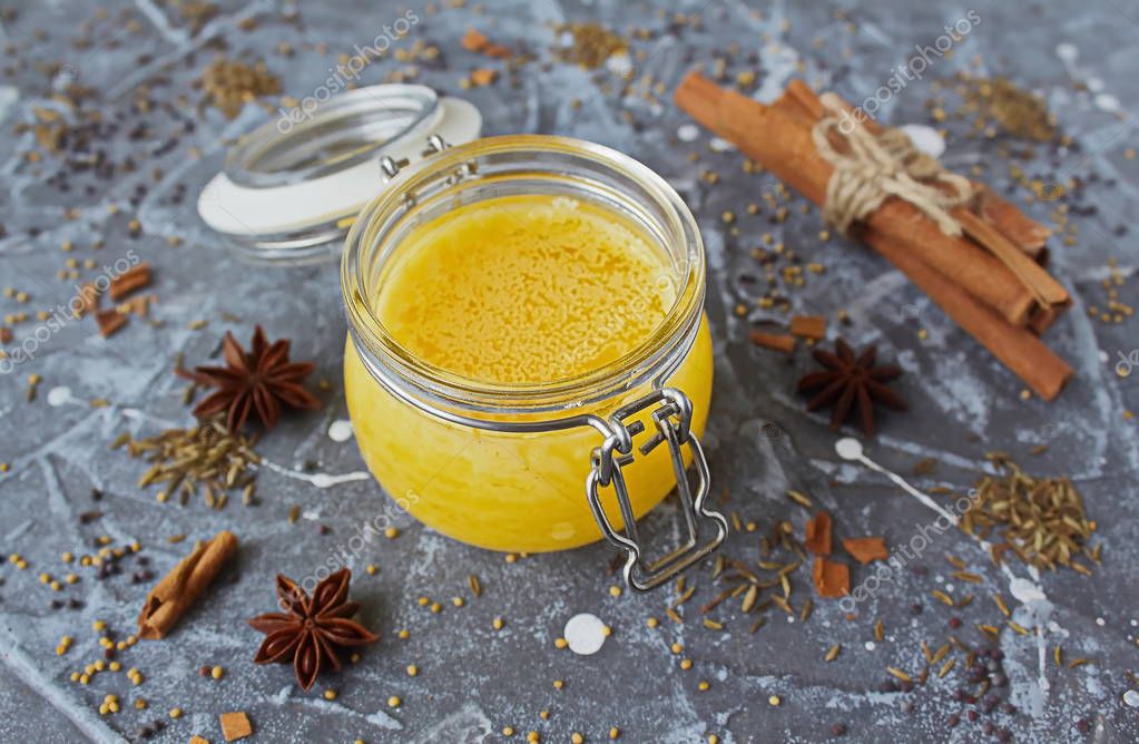 Aceite de Ghee en un frasco de vidrio. Especias: mostaza amarilla ...
