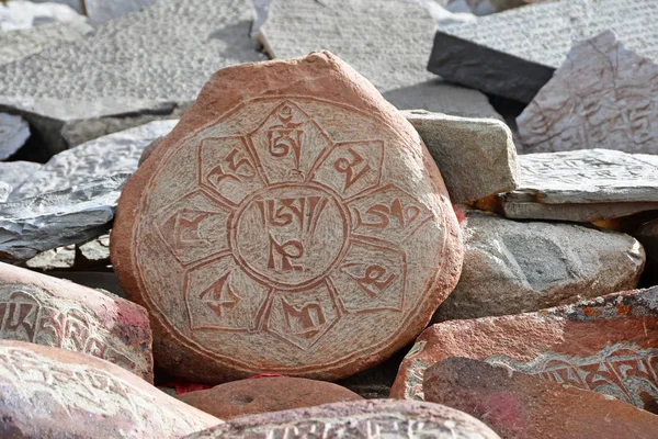 Tíbet. Piedras de oración budistas con mantras y dibujos rituales en el ...