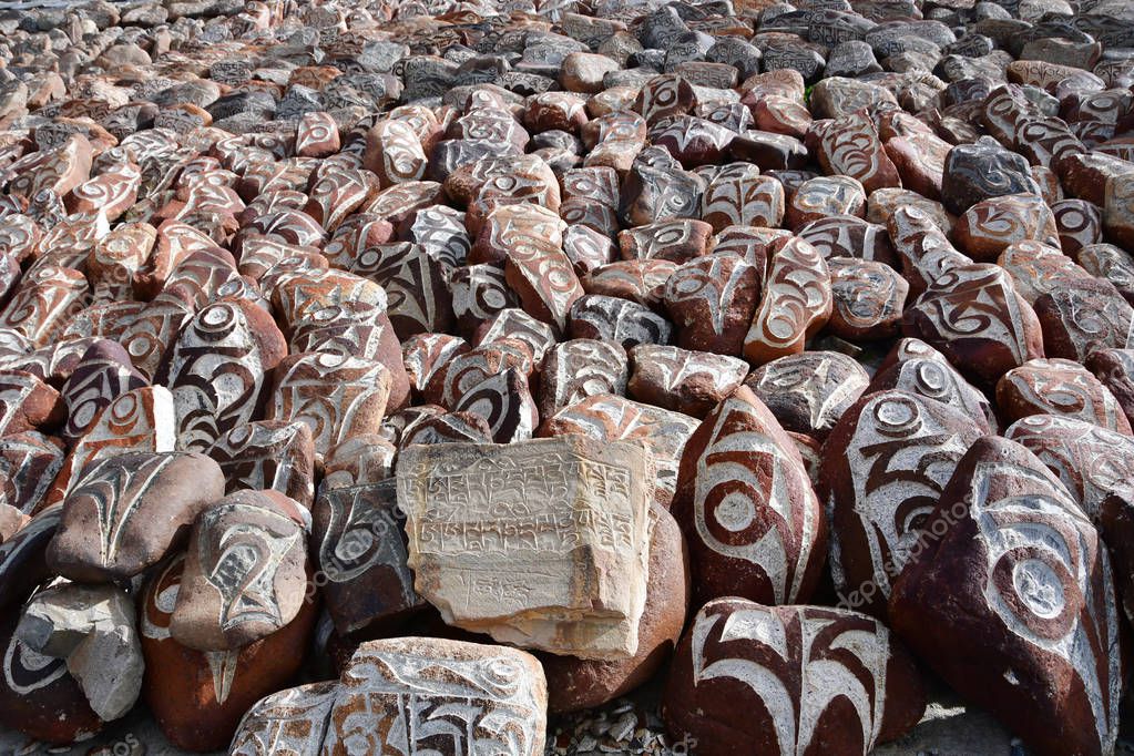Tíbet. Piedras de oración budistas con mantras y dibujos rituales en el ...