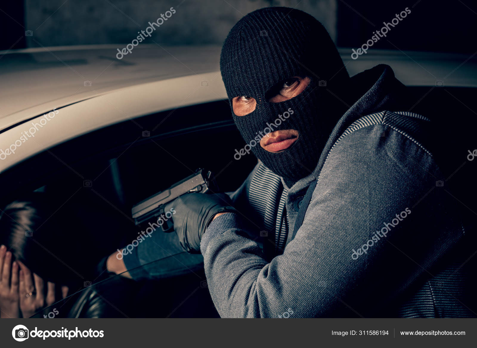 A masked robber with a gun threatens a woman in a car. robber — Stock ...