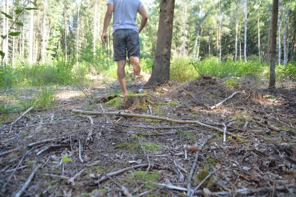 Close-up on the feet - walks across a pebble path in the woods and ...