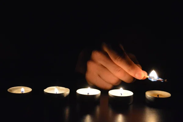light up a row of candles in the dark with a match - light up candle in ...
