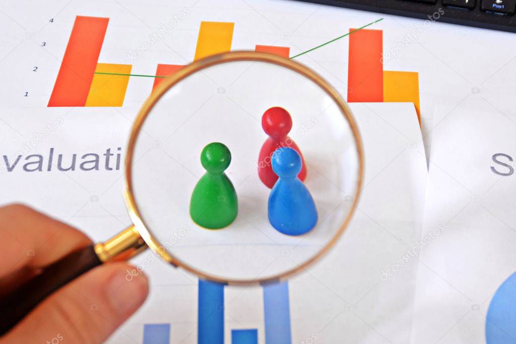 Un joven está sosteniendo una lupa en su mano, mirando las cifras ...