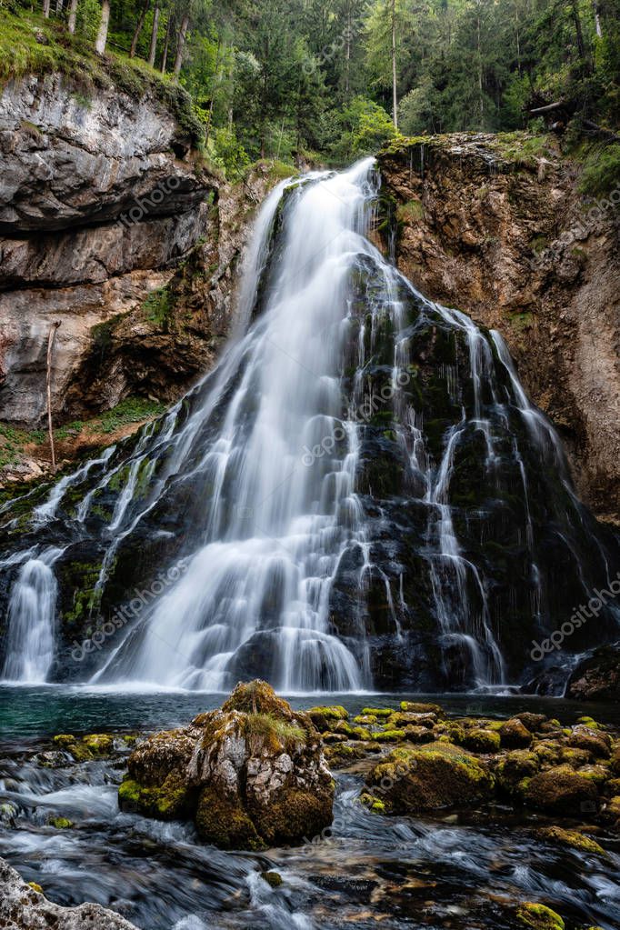 Hermosa vista de la famosa Gollinger Wasserfall con rocas musgosas y ...