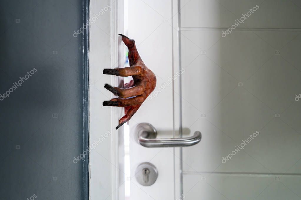 Concepto de horror de Halloween. Imagen de una mano espeluznante emergiendo de la puerta de la ...