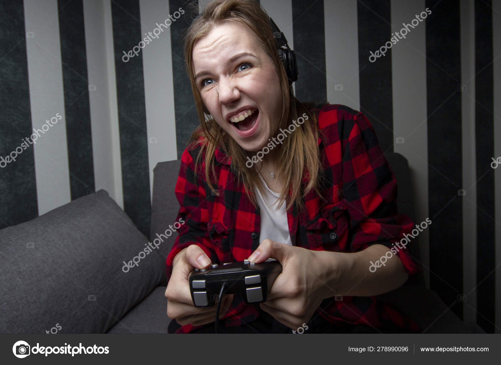Young aggressive girl plays computer games on the joystick at night in ...