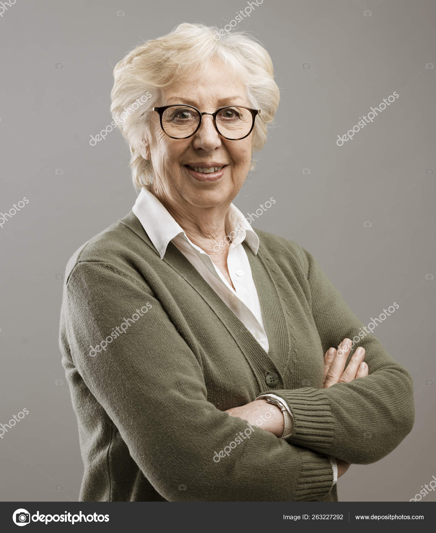 Happy senior lady posing on gray background — Stock Photo © stokkete ...