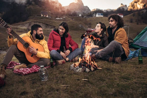 Group of young people around camp fire. - Stock Image - Everypixel