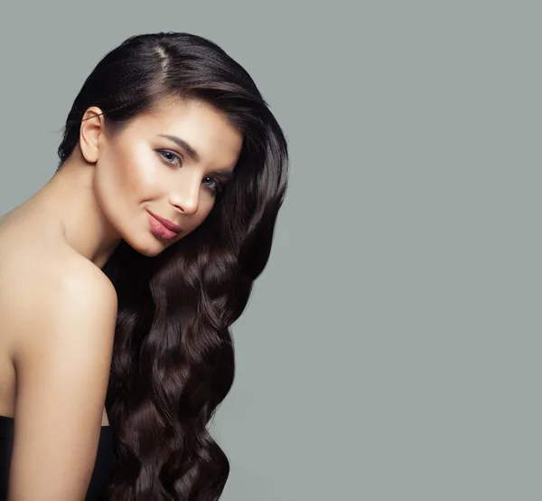 Hermosa mujer morena con pelo largo rizado y maquillaje natural: fotografía de stock ...