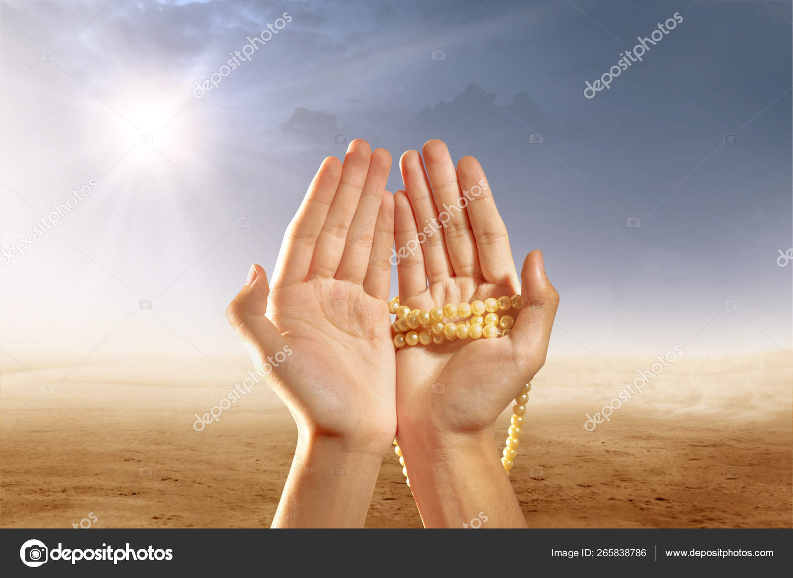 Muslim hands praying with prayer beads on desert Stock Photo by ...