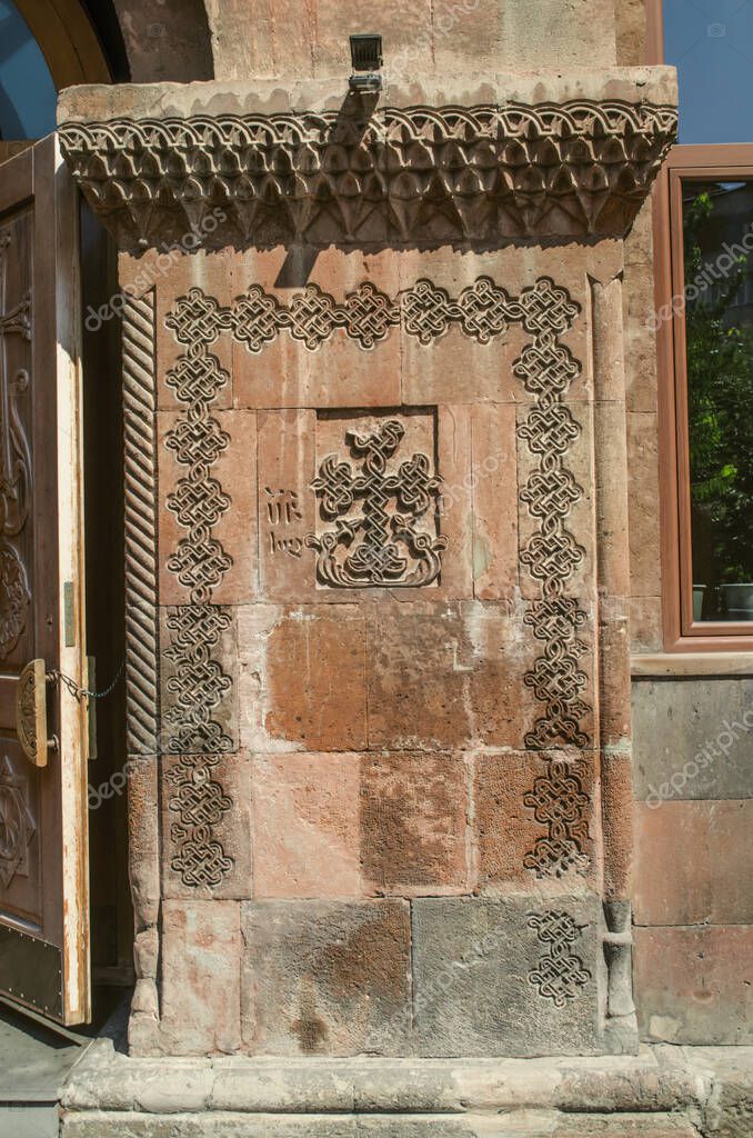 Una de las columnas portantes con dibujos tallados y una cruz bajo ...