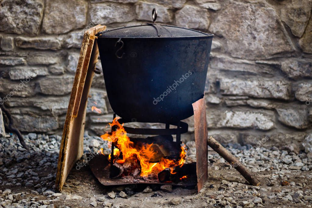 Cocinero tradicional en un caldero de hierro fundido. Comida en una ...