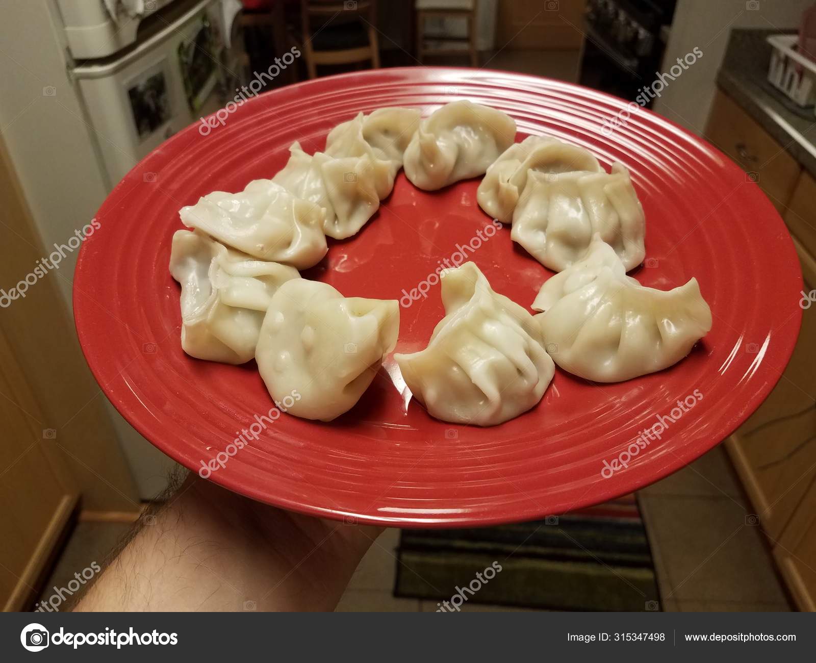 Steamed dumplings on red plate in kitchen — Stock Photo ...